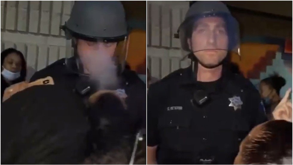 US cop stays calm as protesters blow smoke in his face & give him ...